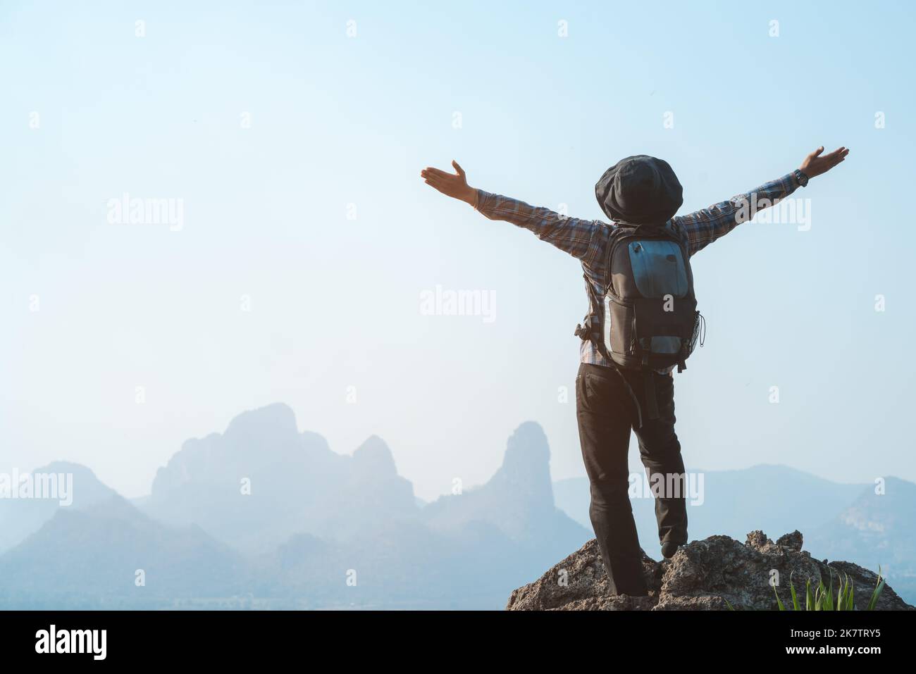 Freedom man hiker outstretched arms stand at cliff edge on mountain top ...