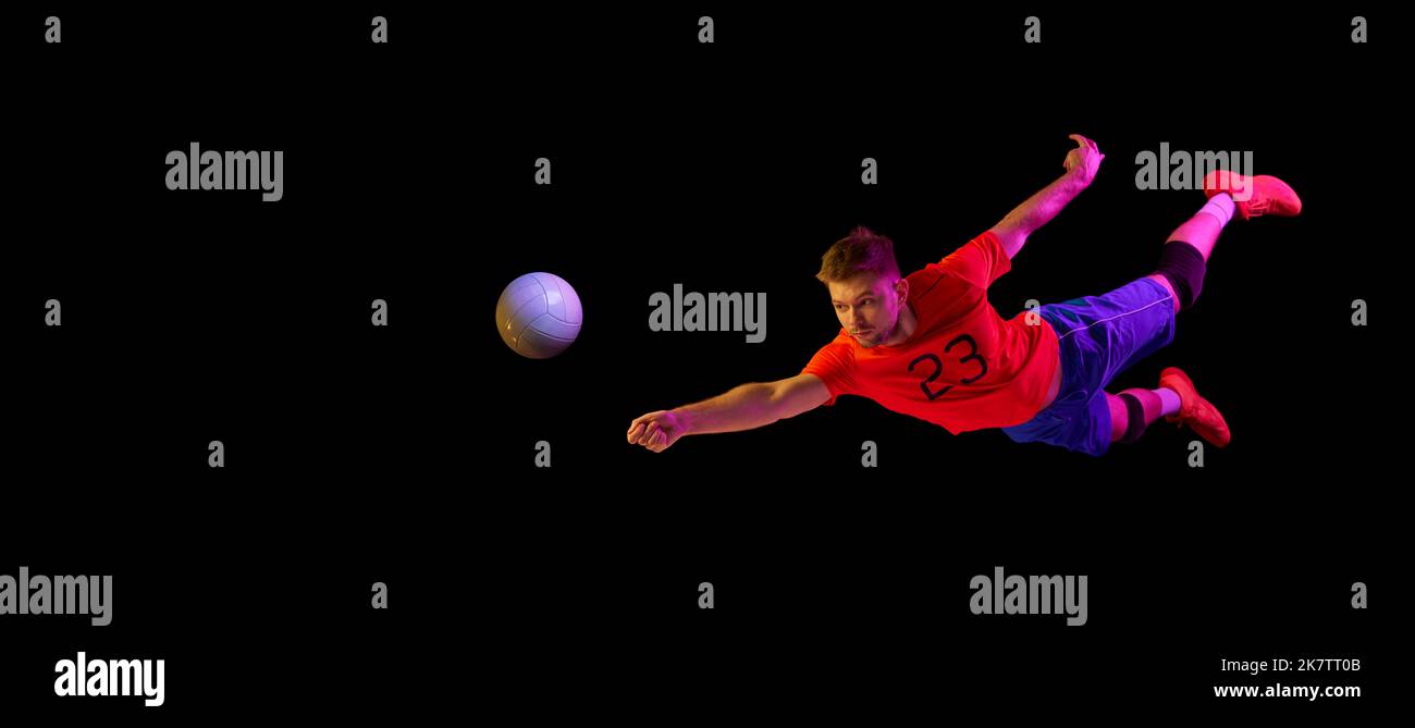 Athlete in motion. Young volleyball player in action isolated on dark ...