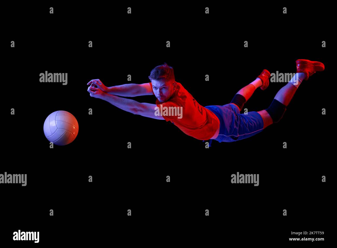 Athlete in motion. Young volleyball player in action isolated on dark ...