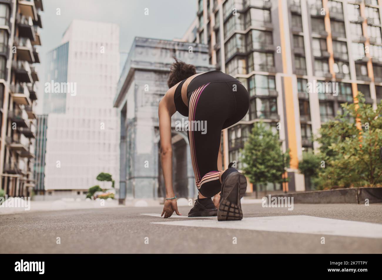 Girl in black sportswear standing on the start of a running route Stock ...