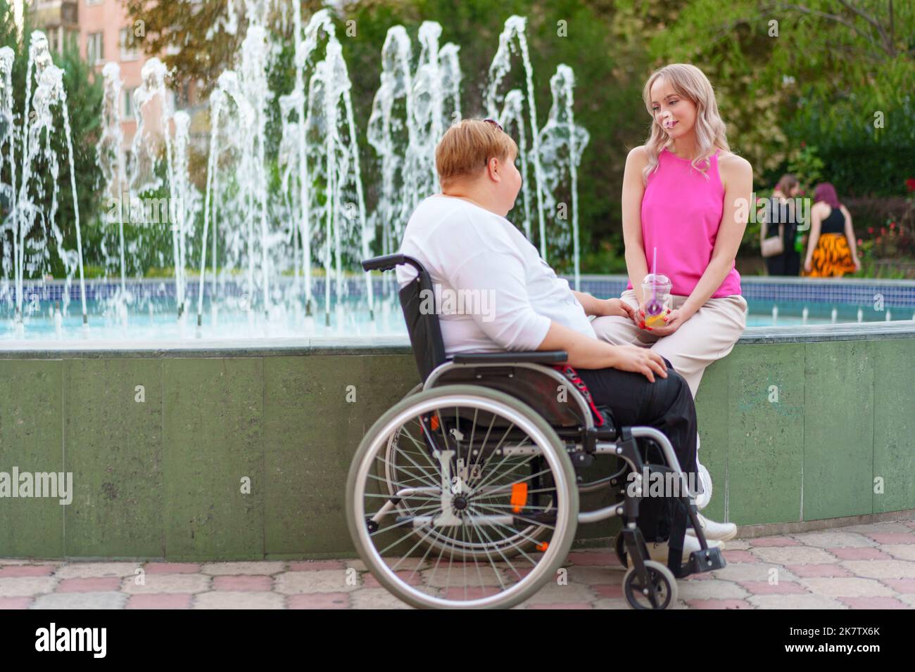 Young daughter taking care of her mother with disability sitting in ...