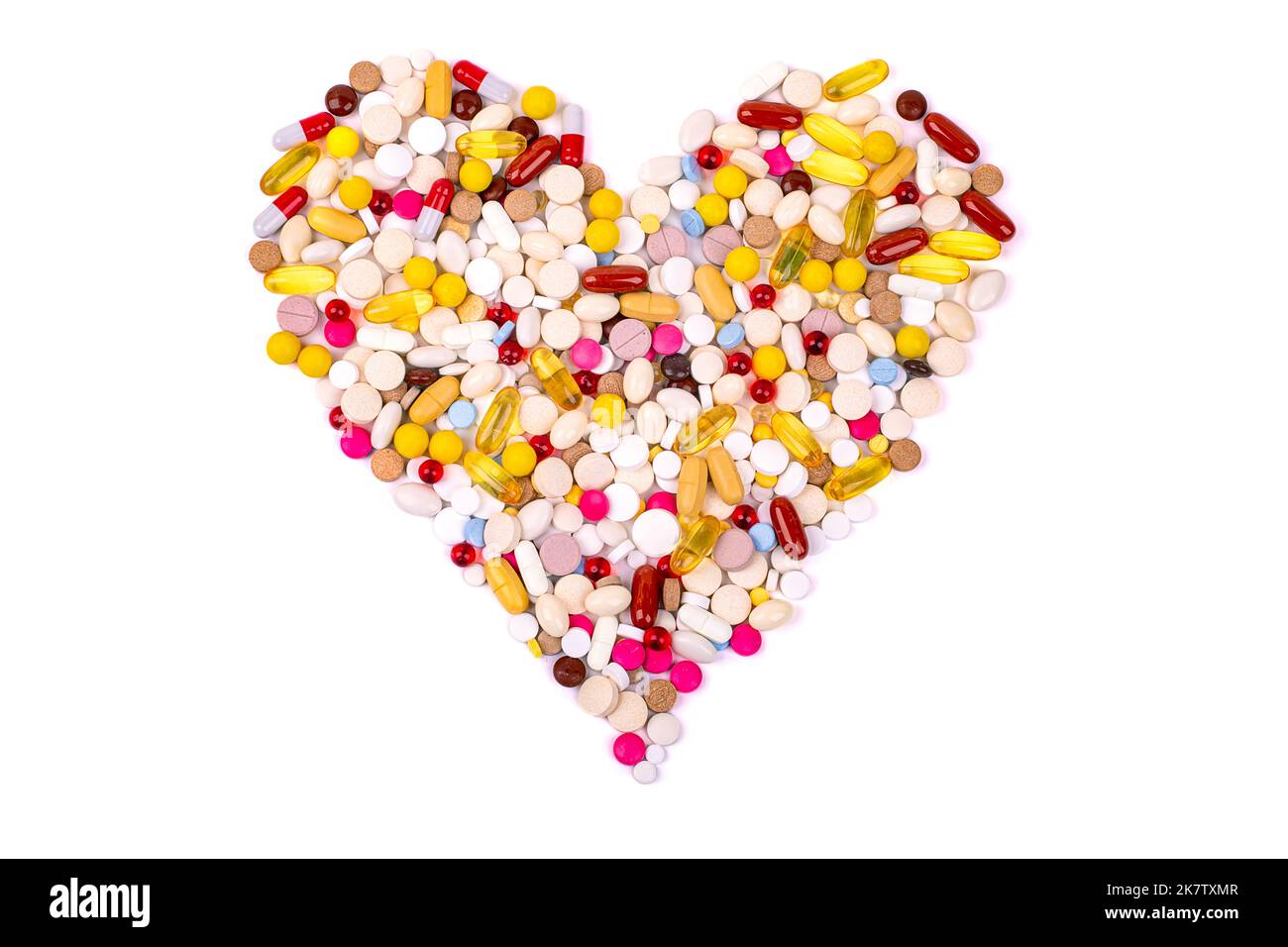 A heart made of multicolored tablets and capsules, isolated on a white ...
