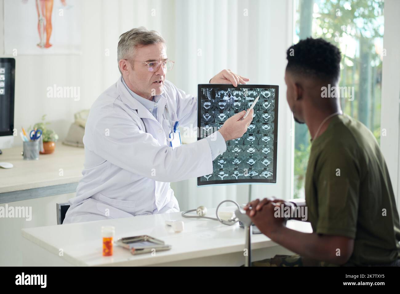Emotional doctor talking to ex-soldier visiting clinic for annual ...
