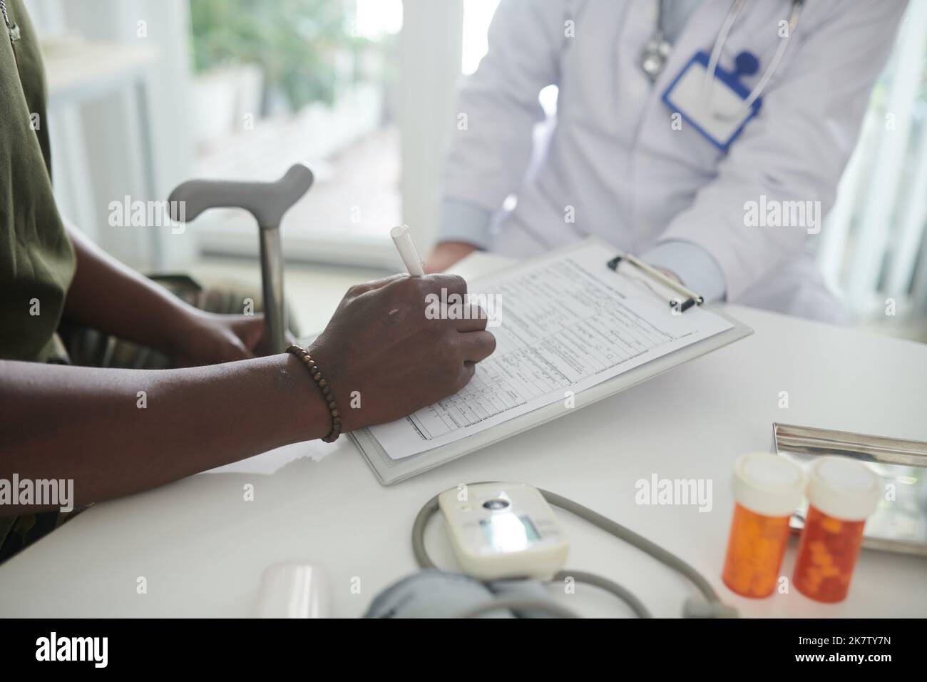 Closeup image of patient filling health insurance form in medical ...