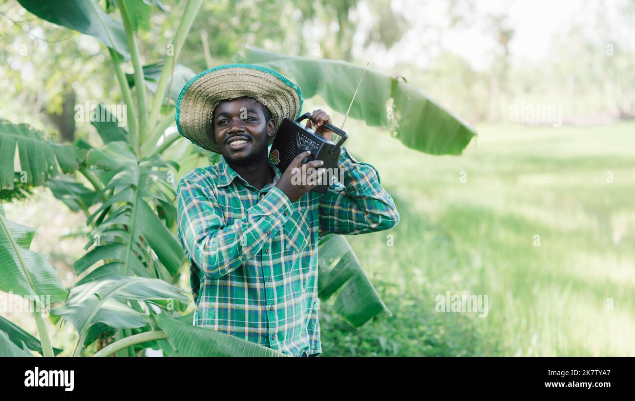 African farmer man listens retro radio broadcast receiver on shoulder ...