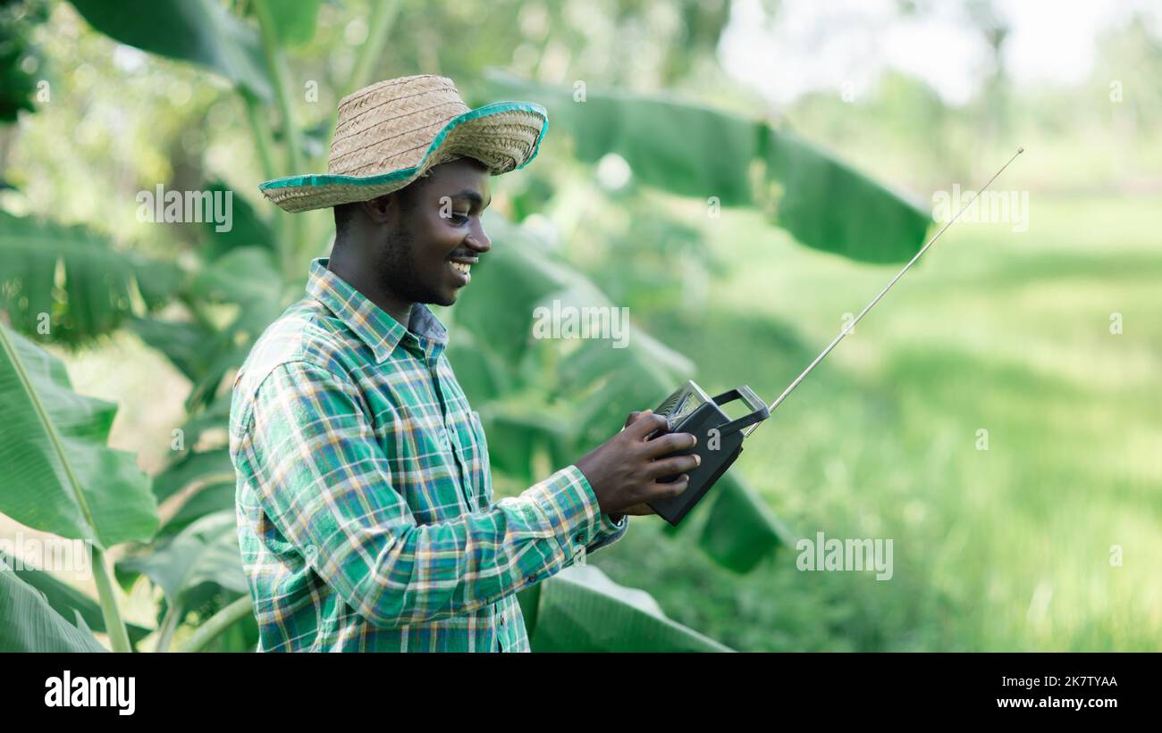African farmer man listens retro radio broadcast receiver on shoulder ...