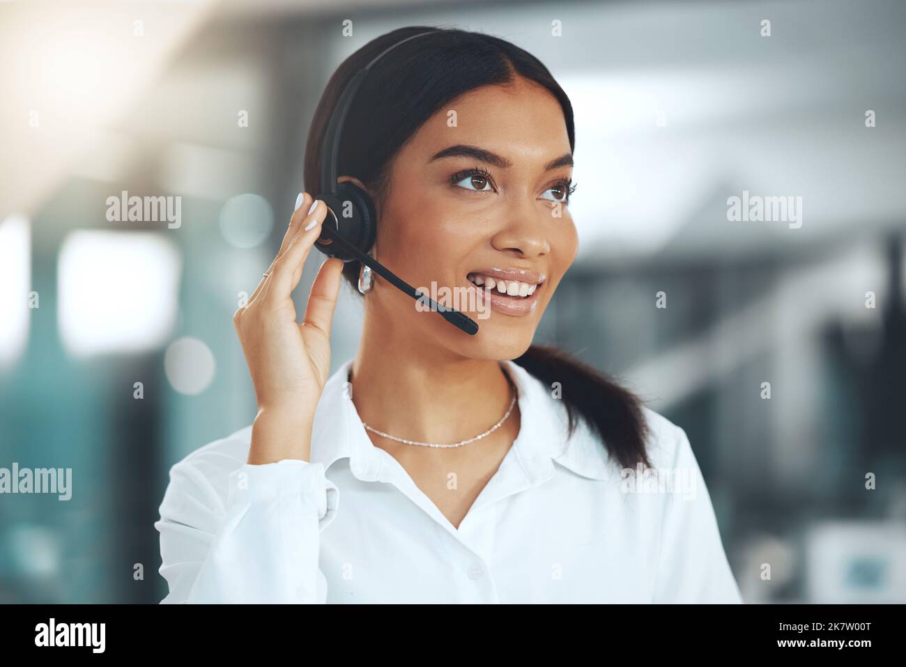Im always ready to help. a young call centre agent standing alone in ...