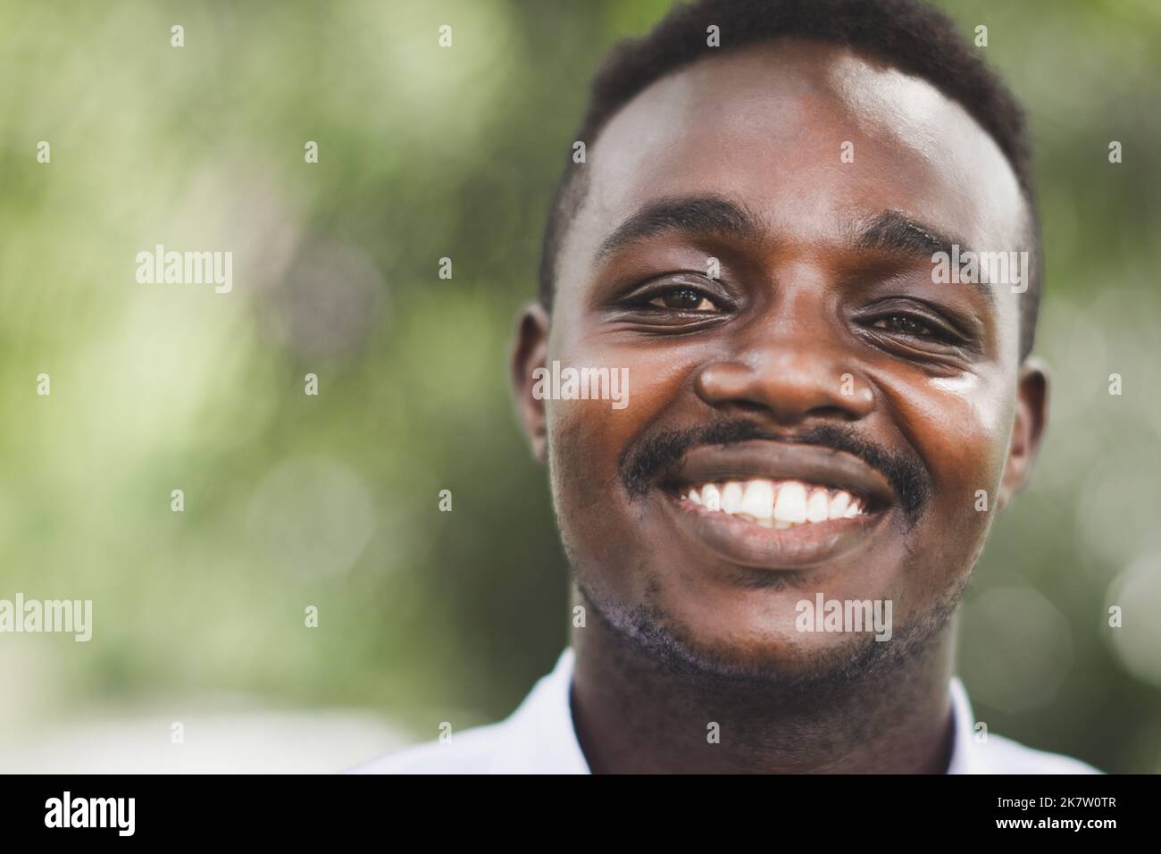 A charming african man with a happy face standing and smiling with a ...