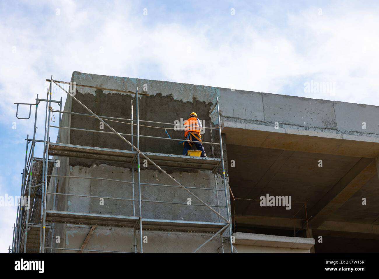 Worker plastering the outside of a building with cement on the ...