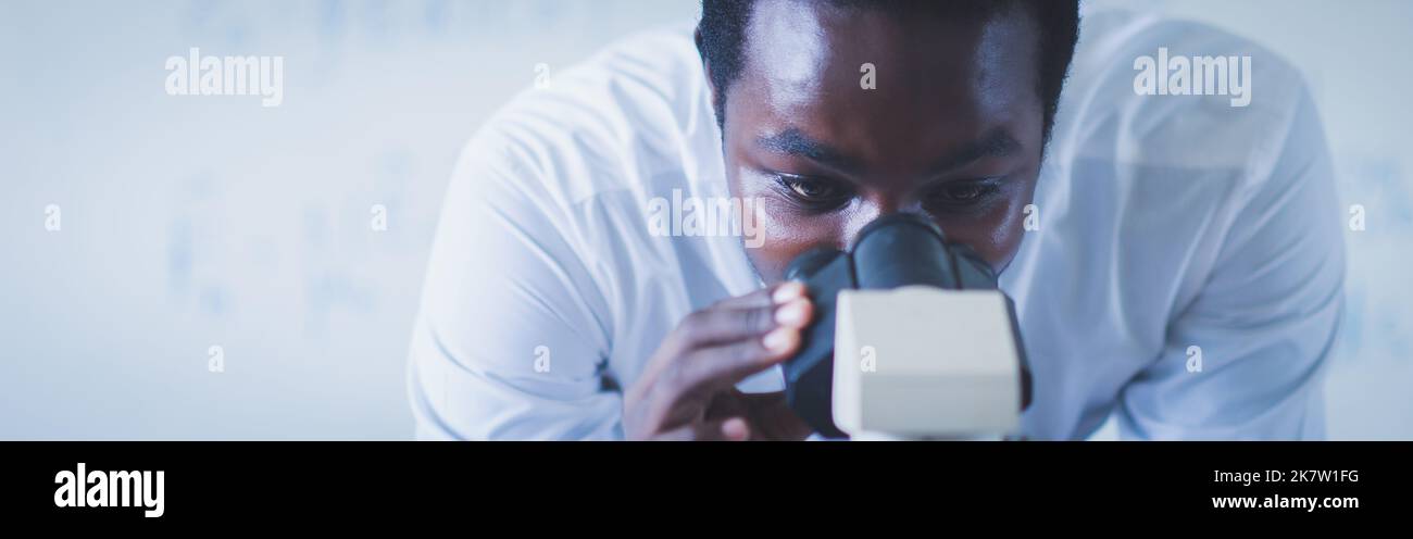 Close Up of a African Male Scientist Looking into the Microscope ...