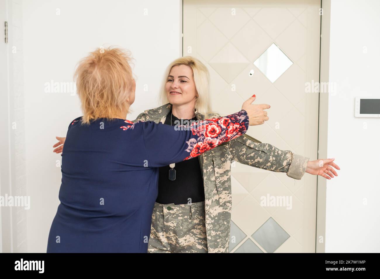 Soldier woman returning home to her family, embracing his mother, close ...