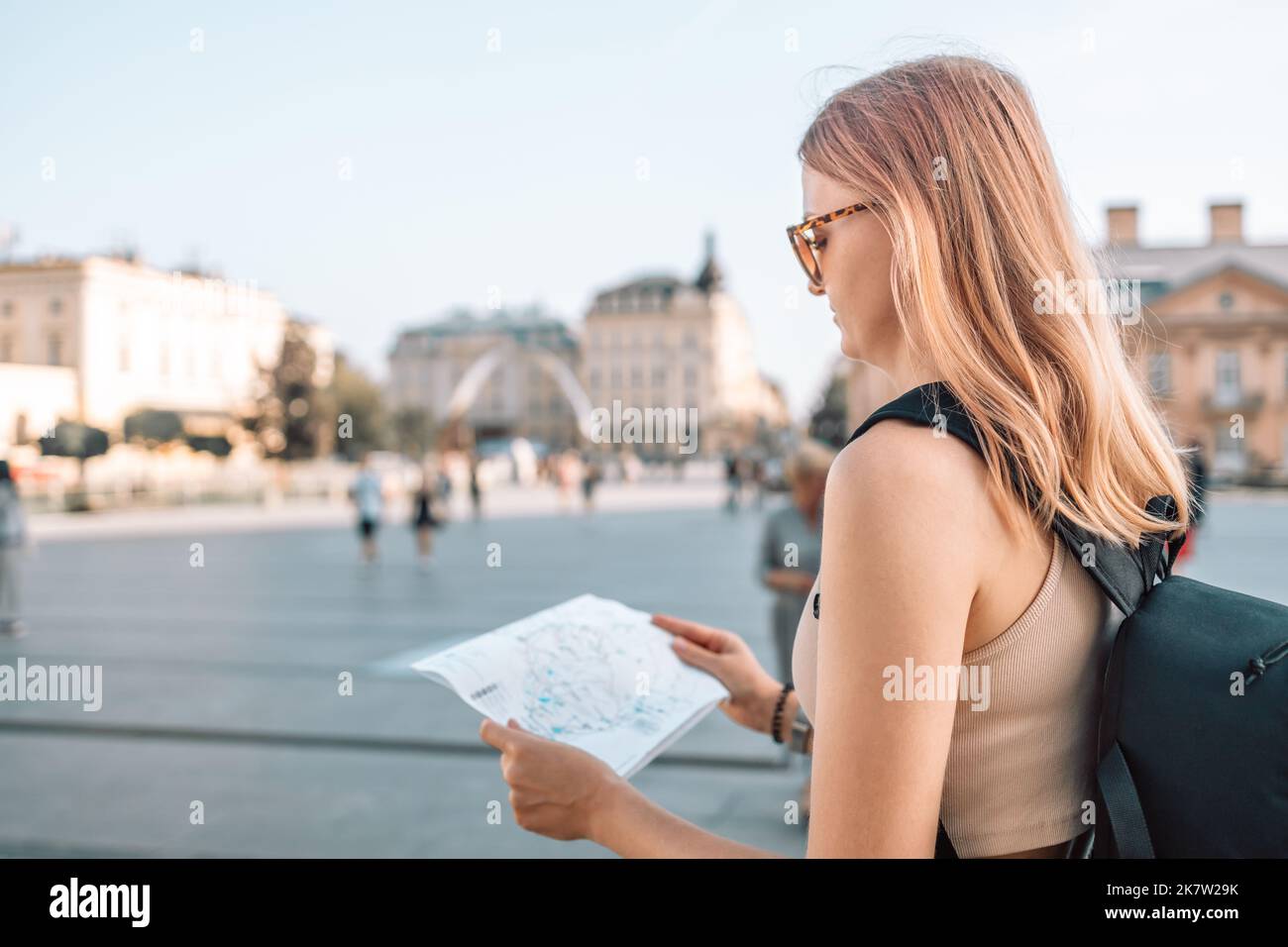 Cheerful woman wanderer with trendy look searching direction on ...