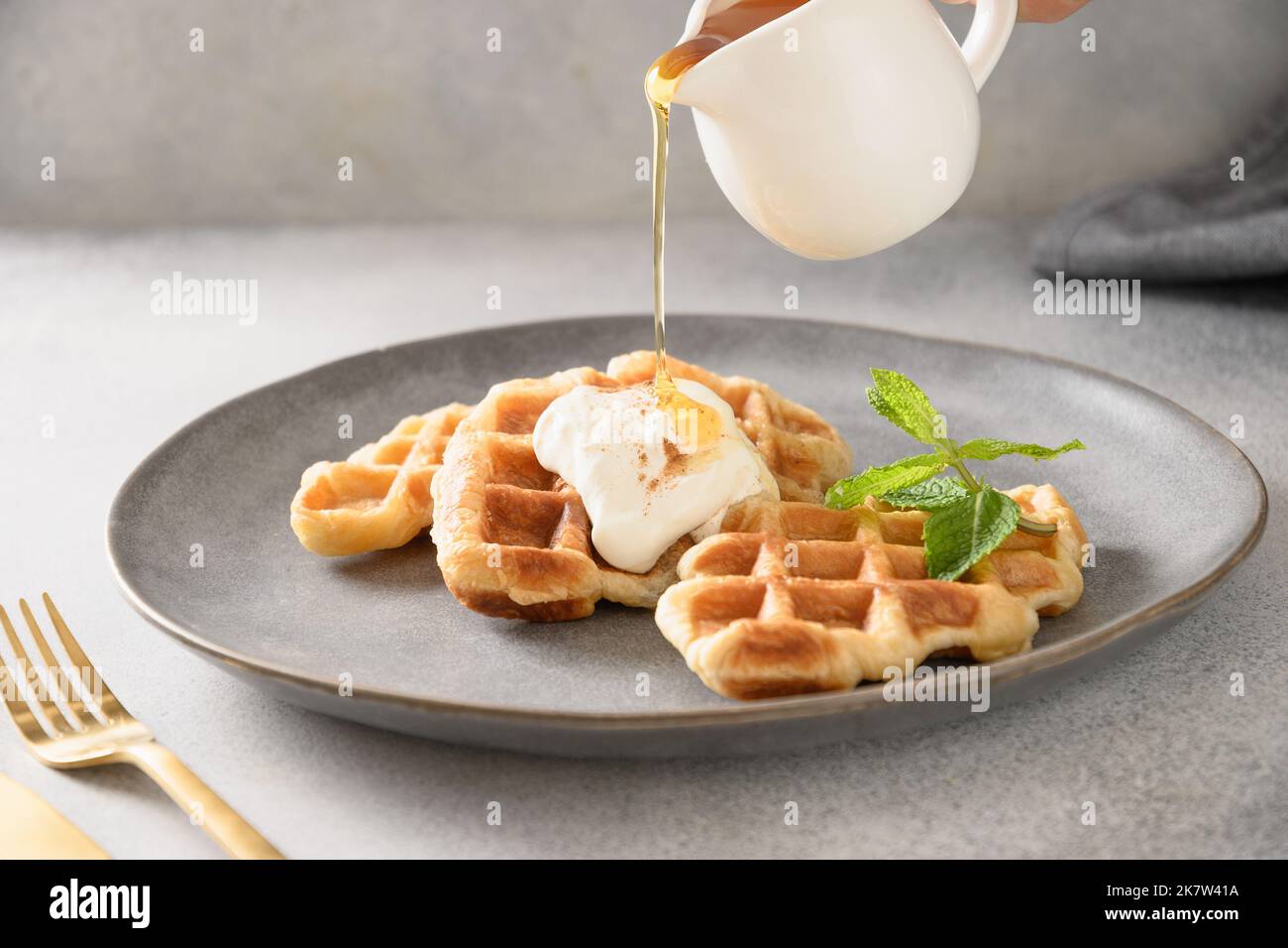 Pouring maple syrup to fresh crispy croffles for delicious trendy ...