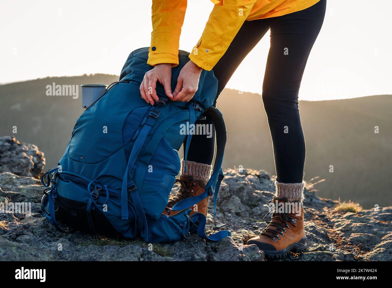 Woman opening backpack after climbing mountain peak. Hiking outdoors ...
