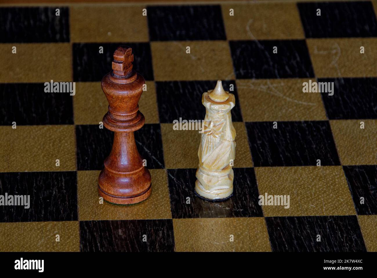 Two opposing Kings represented by chess stand facing each other. A ...