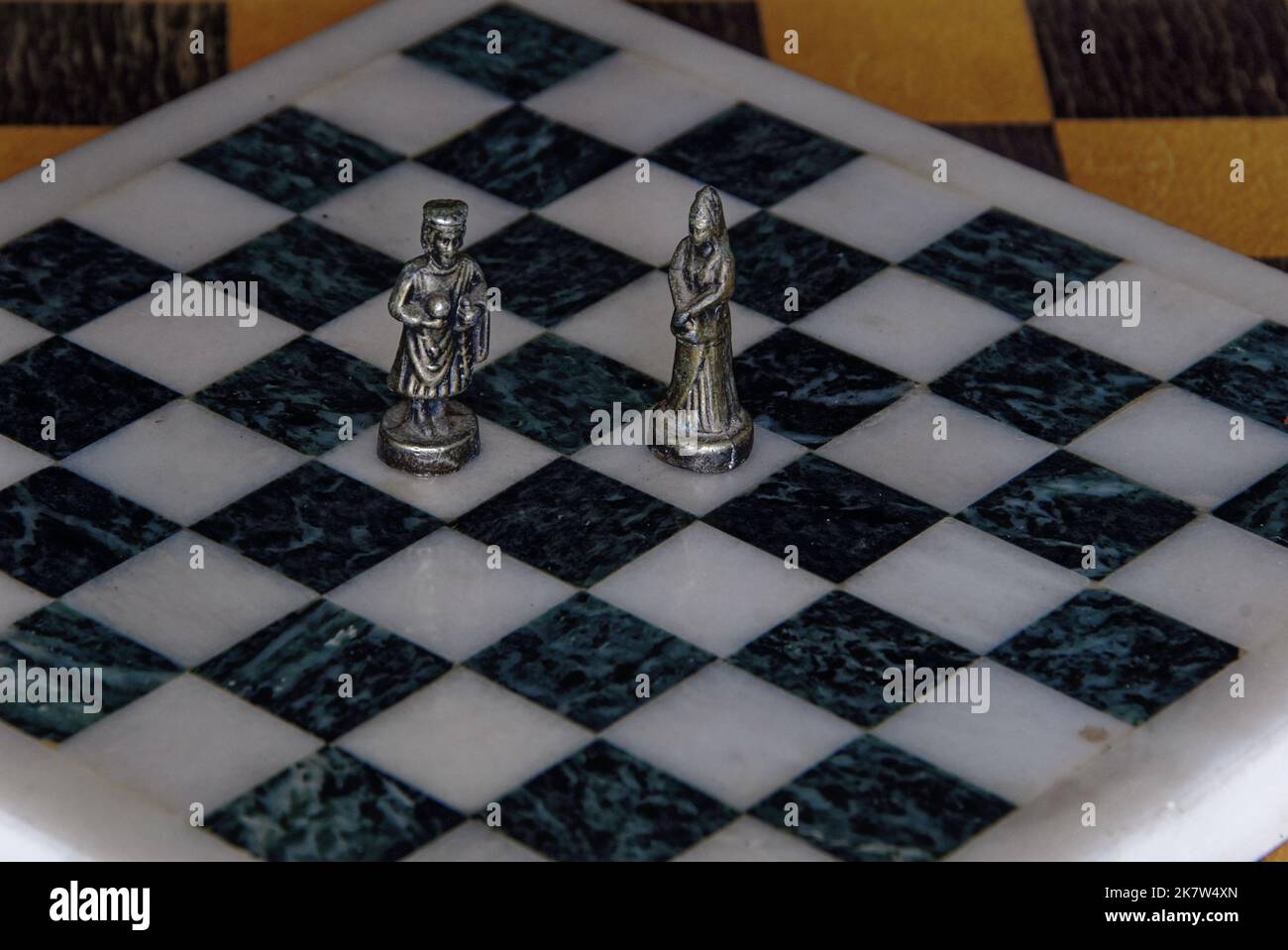 King and Queen chess pieces on a black and white marble chess board ...