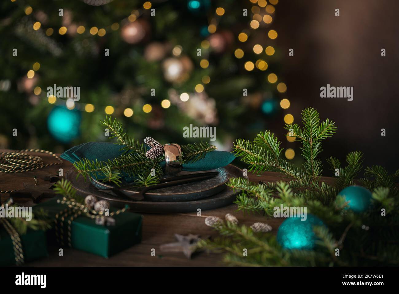 Christmas table setting with black plate, fir tree branches and green ...