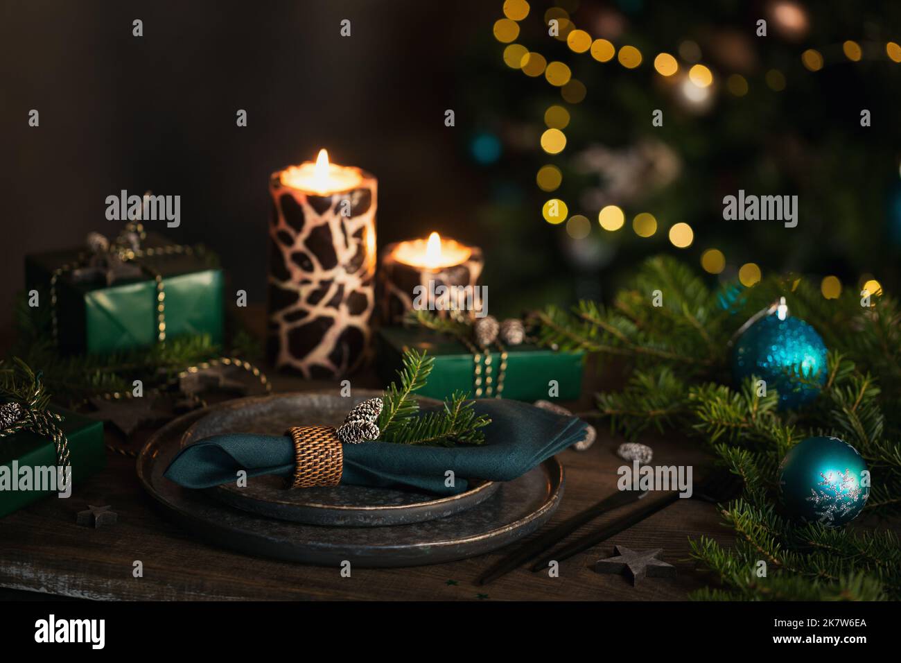 Christmas table setting with plate, fir tree branches and green gift ...