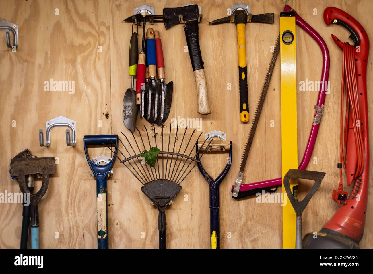 Assortment of DIY gardening tools and equipment hanging organised on ...