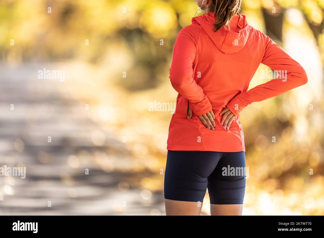 Young woman with an athletic figure and a lower back injury. Back pain ...