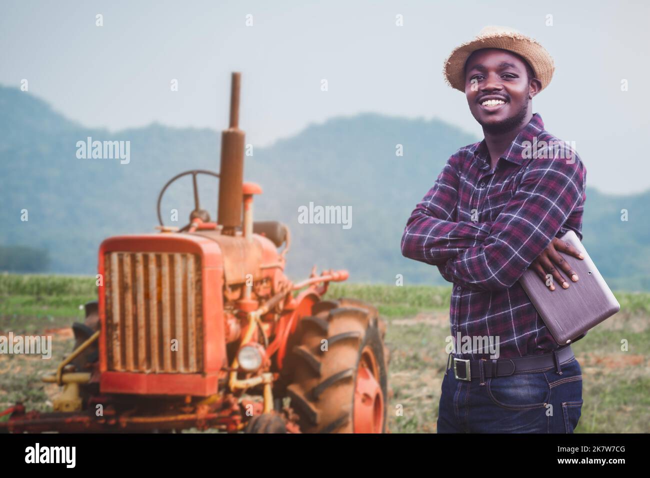 Success african male farmer in checkered shirt and straw hat holding ...