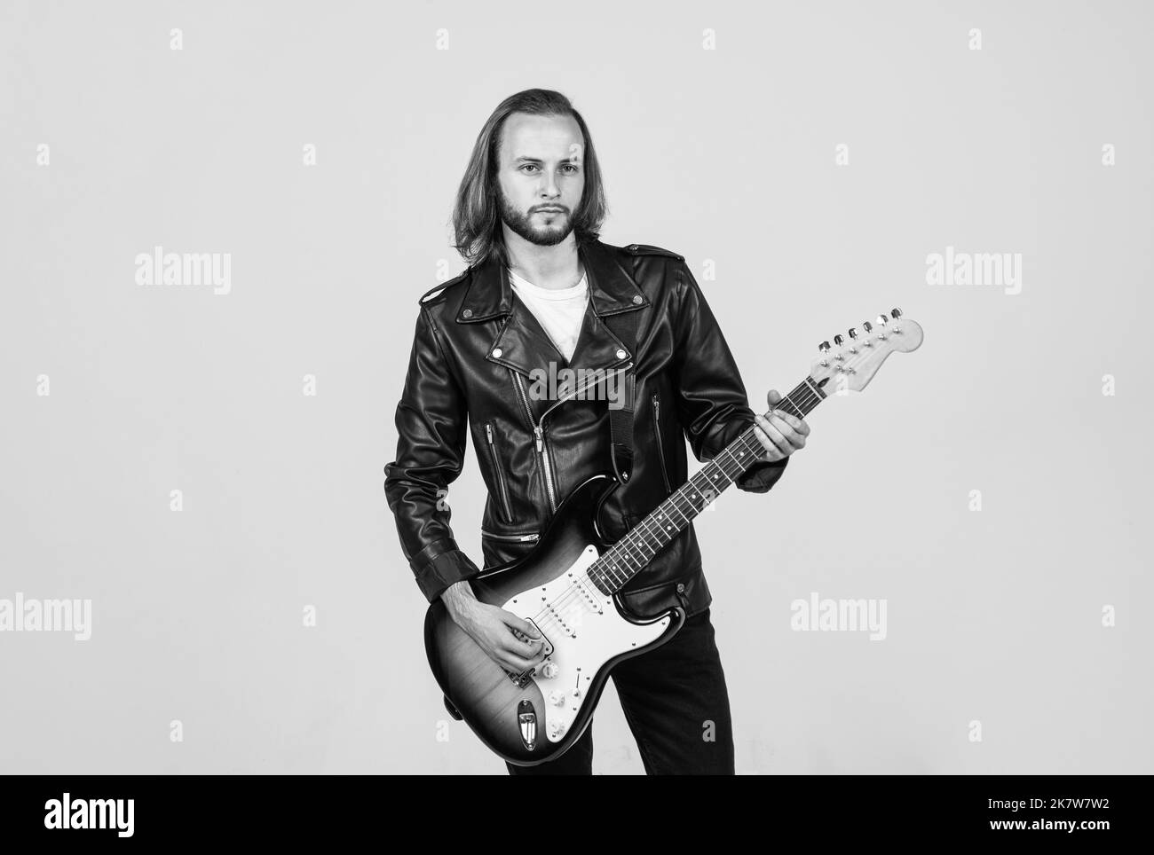 bearded rocker in leather jacket. man long hair play electric guitar ...