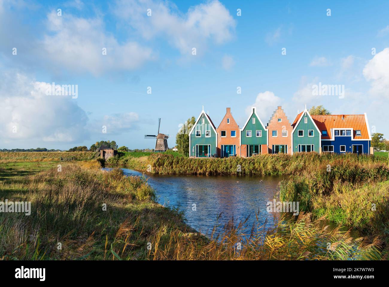 small colorful houses next to historic windmill in dutch town of ...
