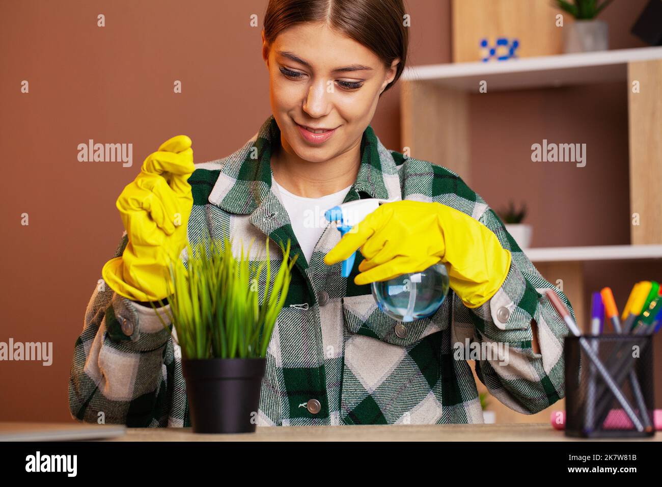 Woman looking after house plant hi-res stock photography and images - Alamy