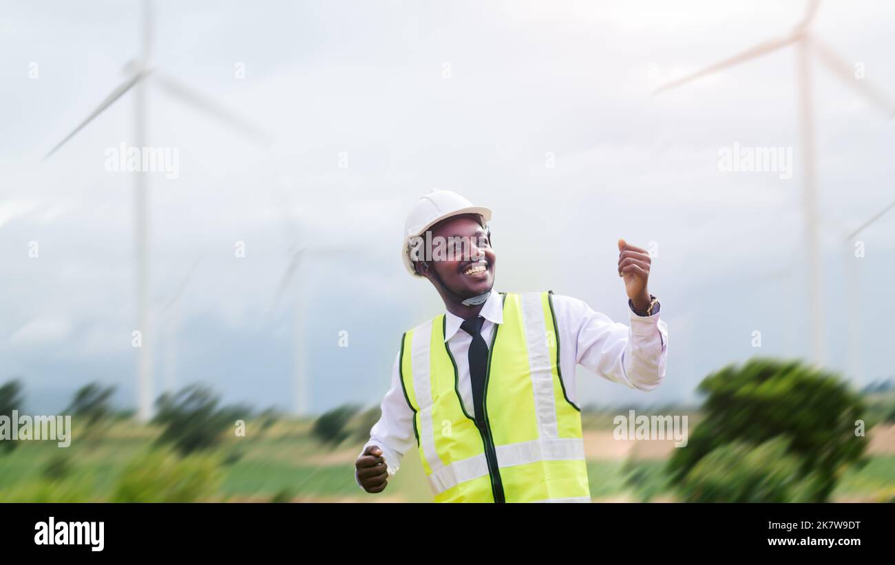 Success african engineer man stands front wind turbines generating ...