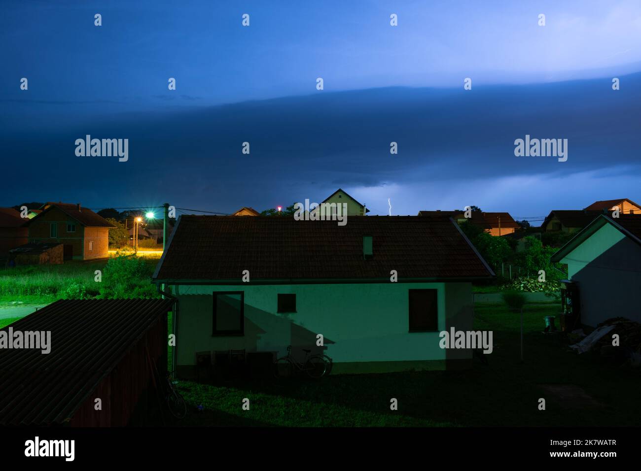 Lightning glow in clouds above suburbs at night, thunderstorm at night ...
