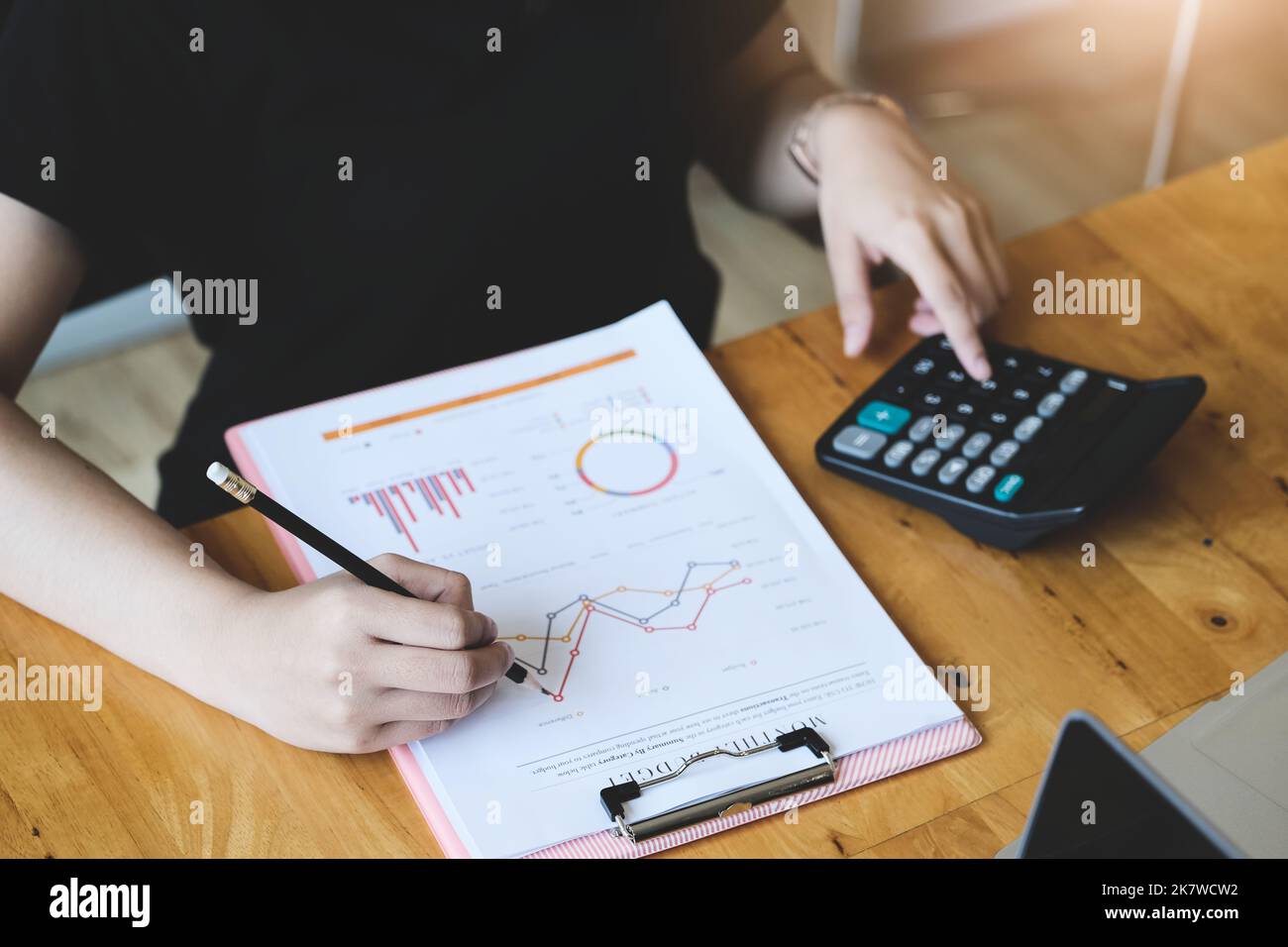 Business woman using document and using calculator to review balance ...