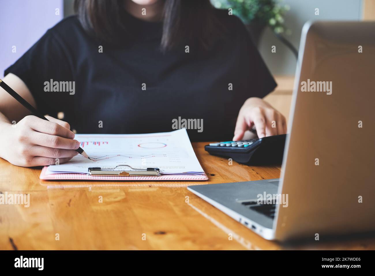 Business woman using document and using calculator to review balance ...