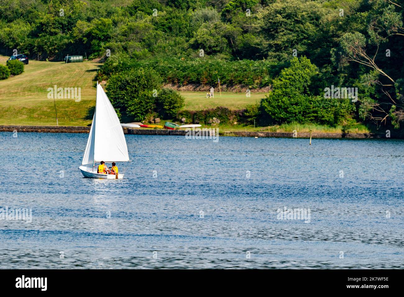A boat sailing a river in an Asturias harbor with huge white wings ...