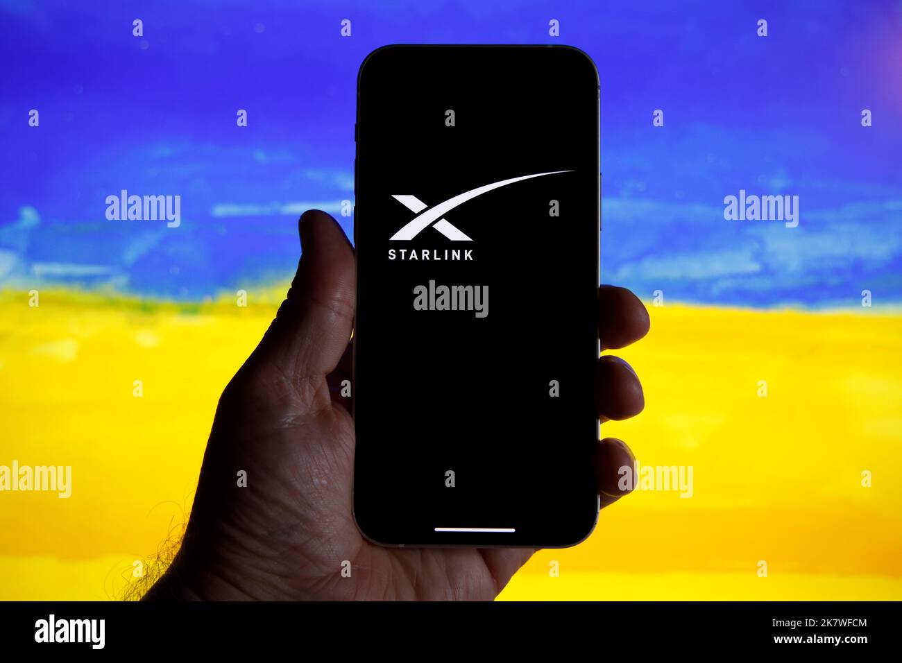 The Starlink logo is seen on a mobile device with a Ukrainian flag in ...