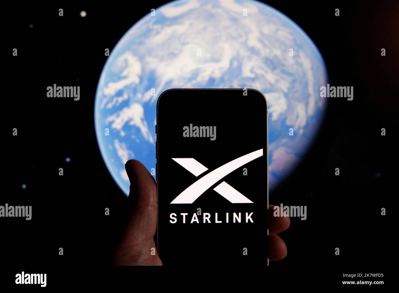 The Starlink logo is seen on a mobile device with an grahpic ...