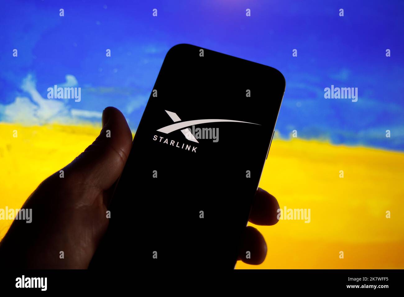 The Starlink logo is seen on a mobile device with a Ukrainian flag in the background in this ...