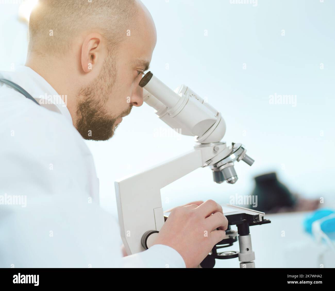 scientist using a microscope in the lab. side view Stock Photo - Alamy