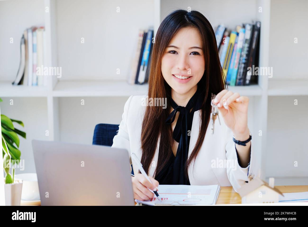 Accountant, businessman, real estate agent, Asian business woman handing house keys to customers ...
