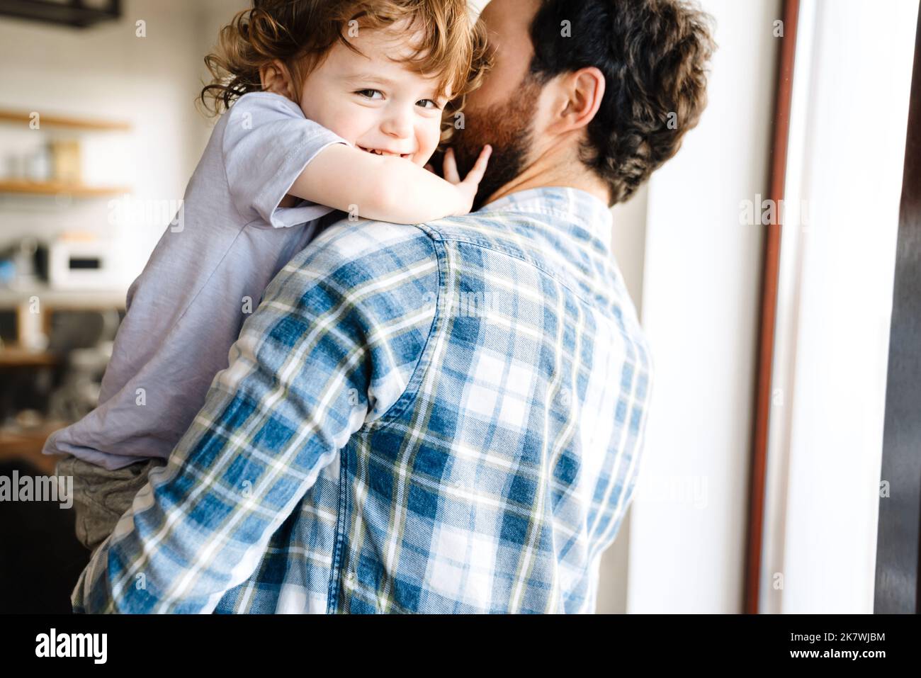 Smilling middle aged father holding his little son standing at the ...
