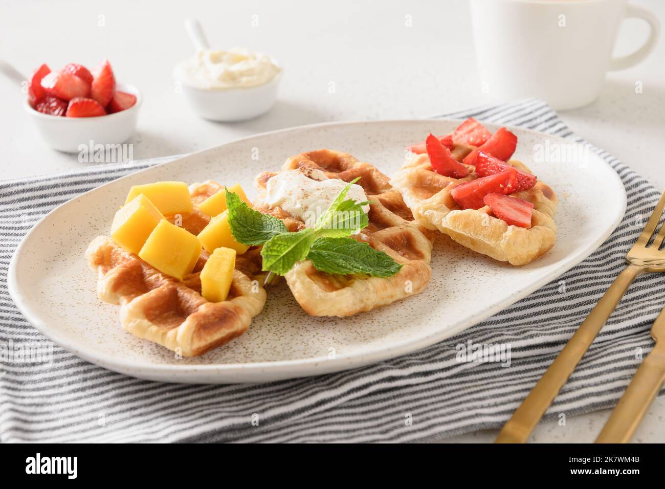 Crispy croffles with different fruits topping of strawberries, mango on ...
