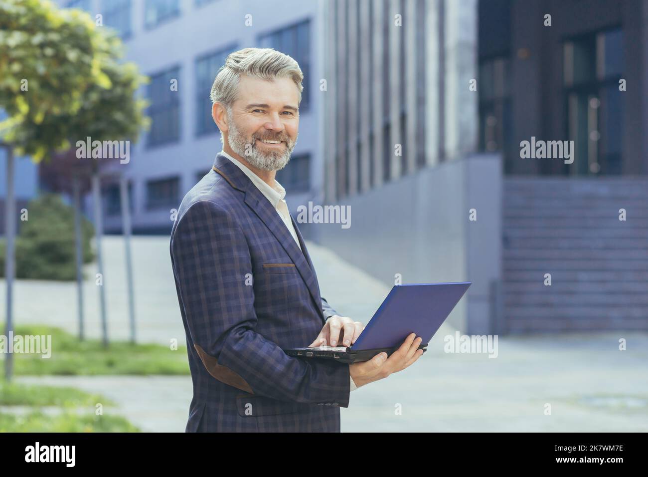 Portrait of mature businessman outside modern office building, senior ...