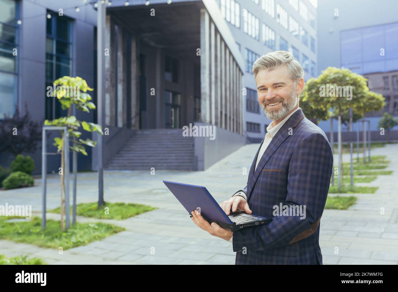 Portrait of mature businessman outside modern office building, senior ...