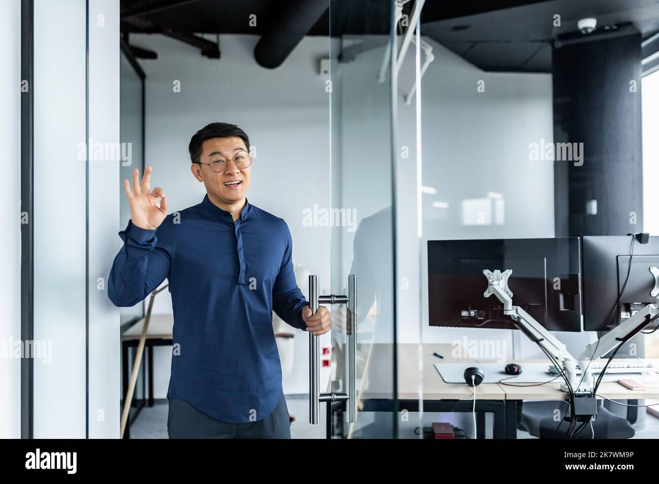 An Asian businessman looks at the camera and smiles, the man shows the ...