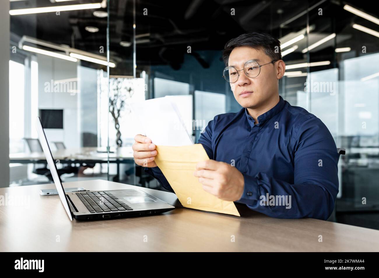 Serious and focused businessman reading received letter, asian man ...