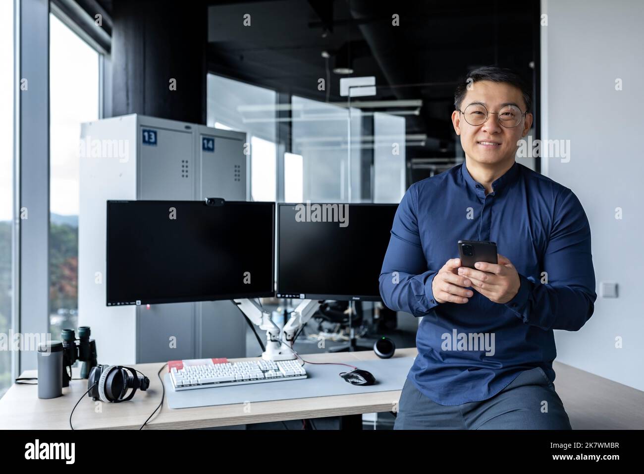 Portrait of successful businessman, man holding smartphone, asian man ...