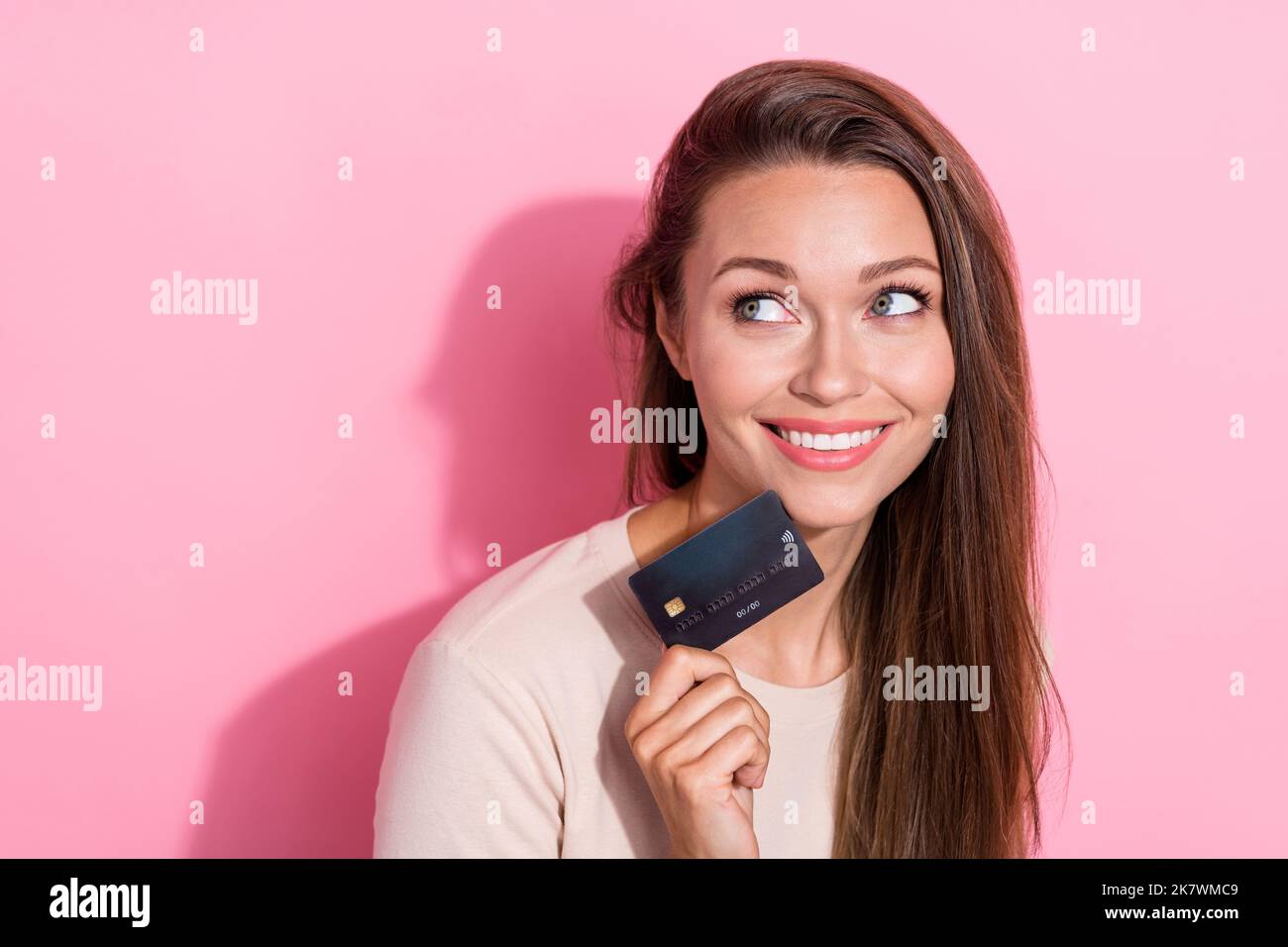 Photo of cheerful pretty person toothy smile arm hold debit card look ...