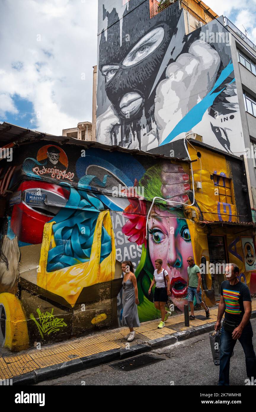 People walk past walls decorated with murals and graffiti in downtown ...