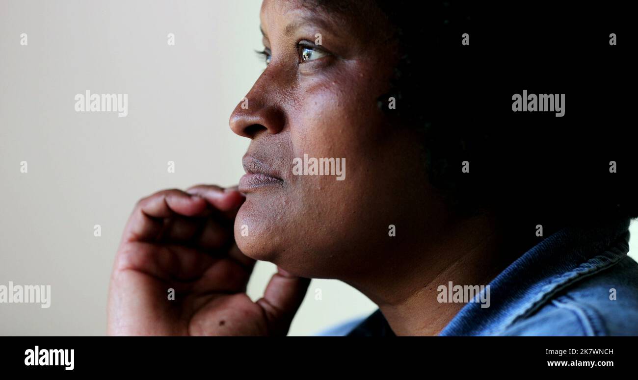Pensive black woman close-up face. candid contemplative person thinking ...