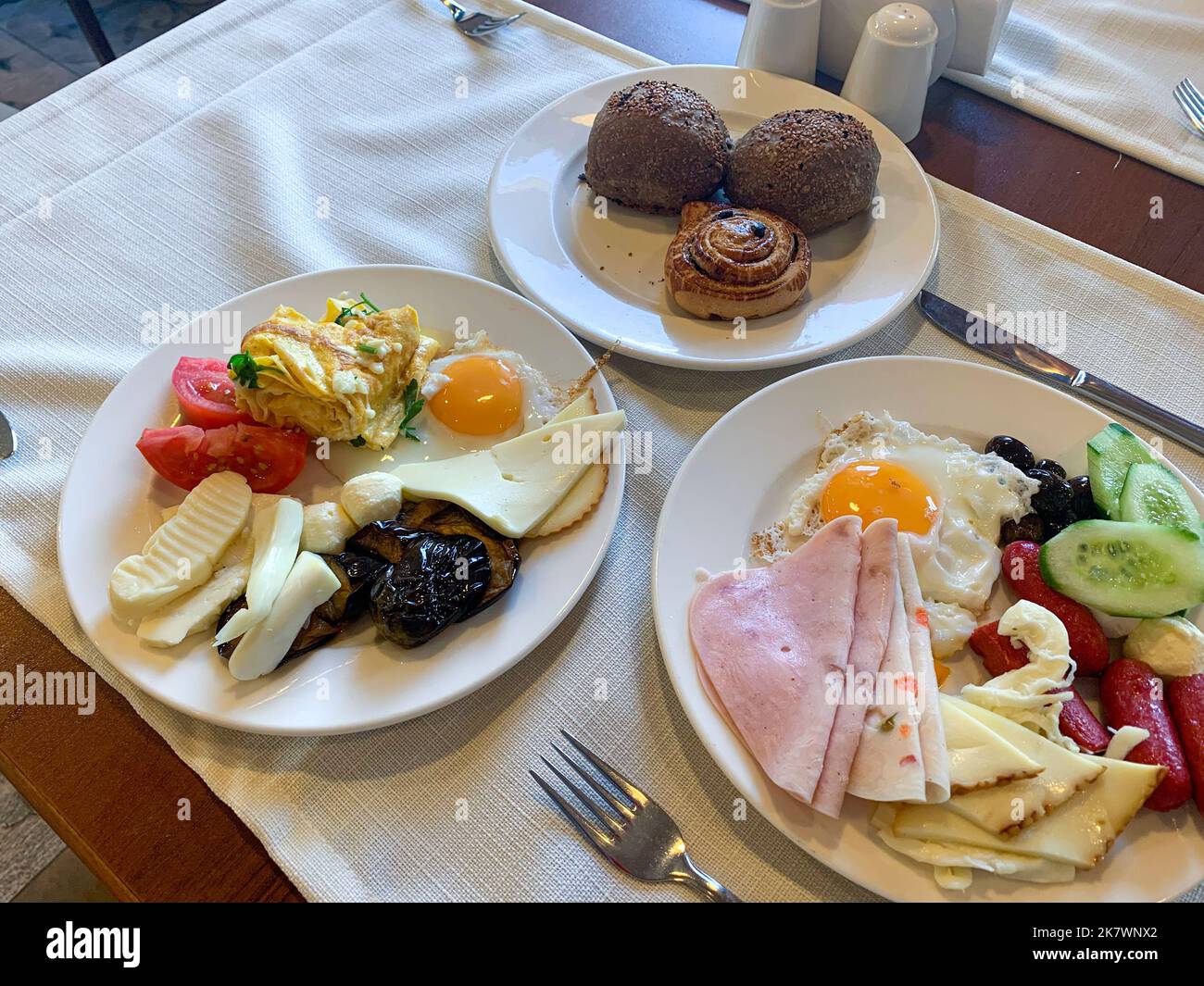 Lunch. Plates of eggs, ham, cheese and vegetables on table. Studio ...