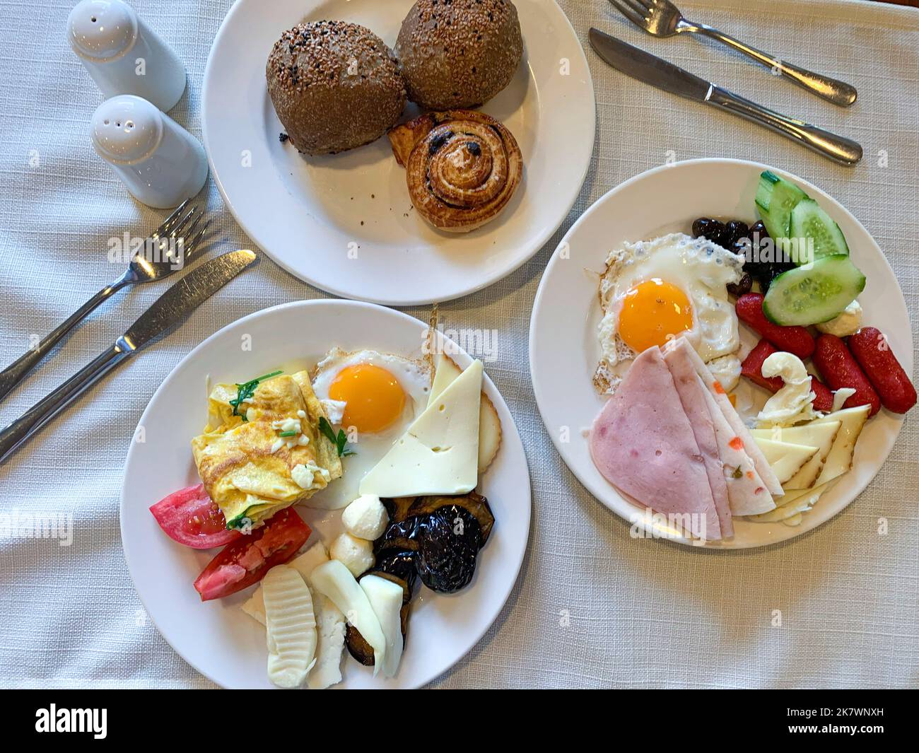 Lunch. Plates of eggs, ham, cheese and vegetables on table. Studio ...